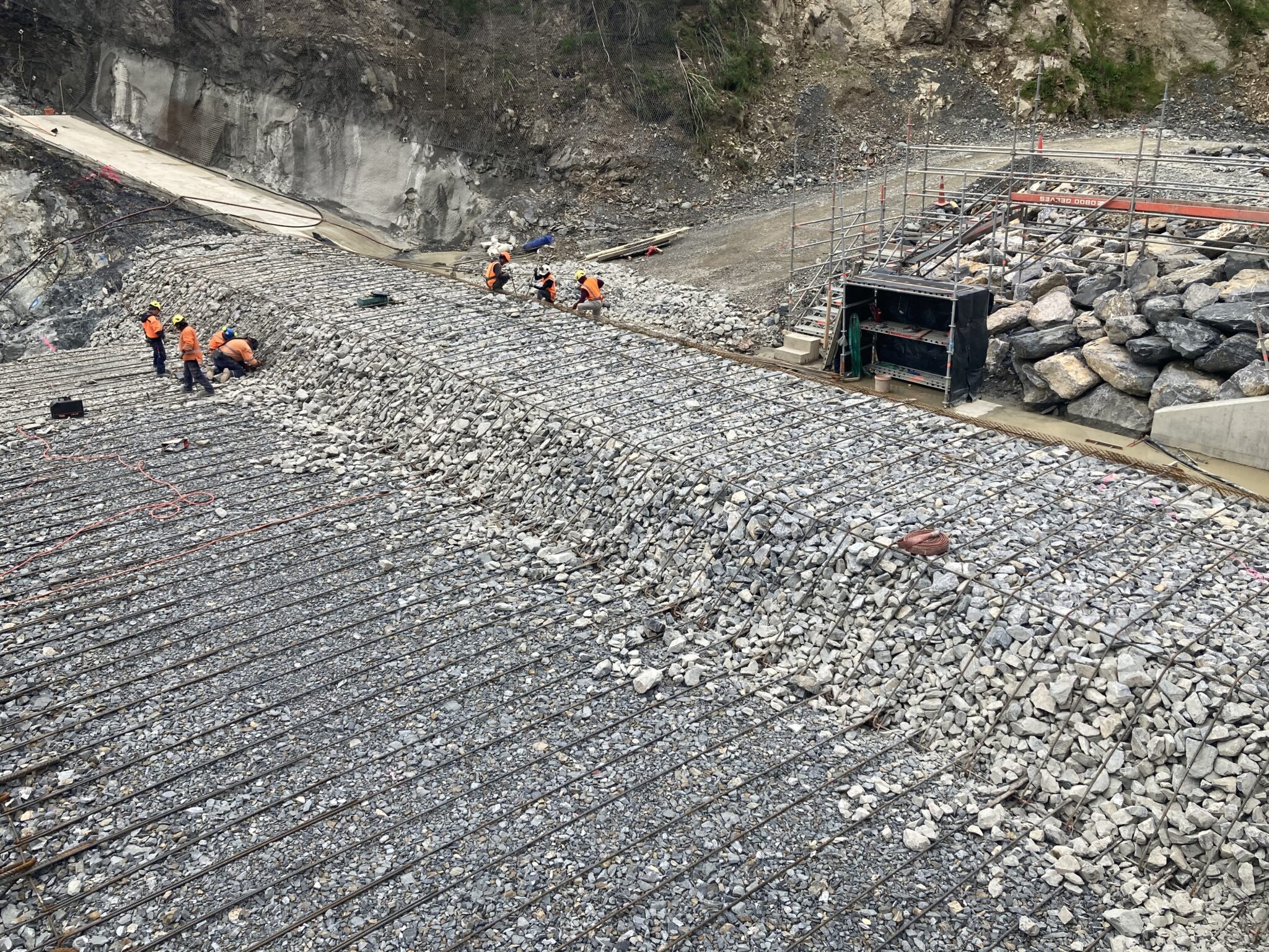 Tension and welding reinforcing on LHS reinforced rockfill embankment ...